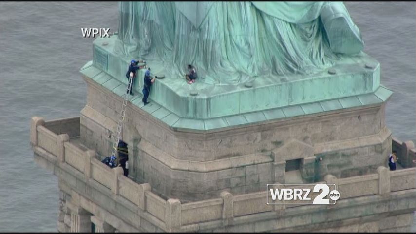 Woman climbs side of Statue of Liberty